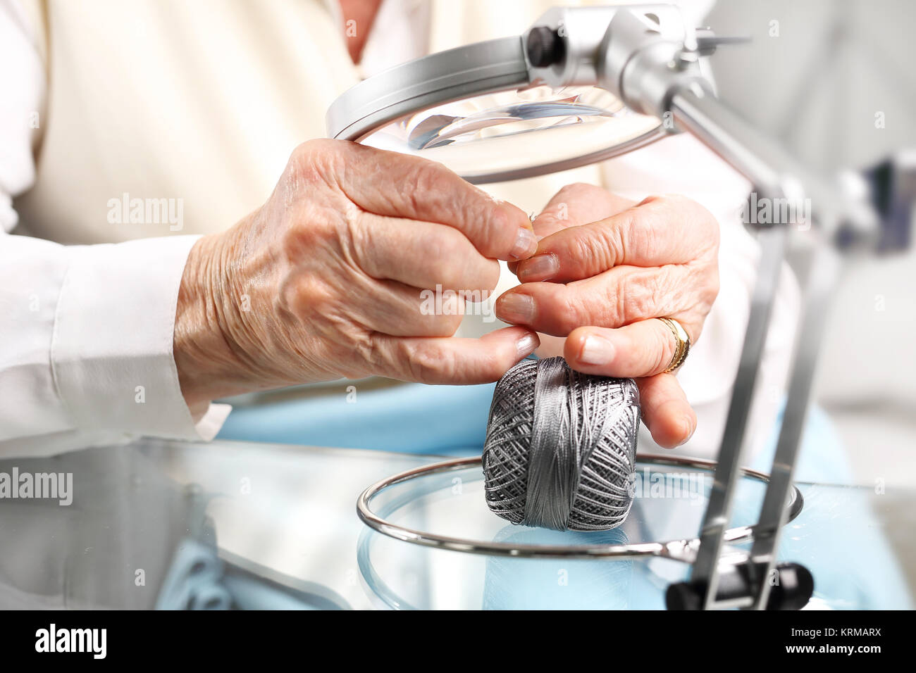 threading the needle under the magnifying glass grandma's hobby ...