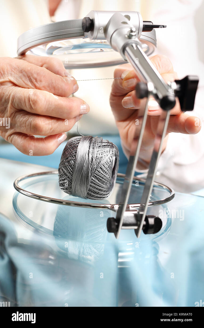 threading the needle under the magnifying glass grandma's hobby ...