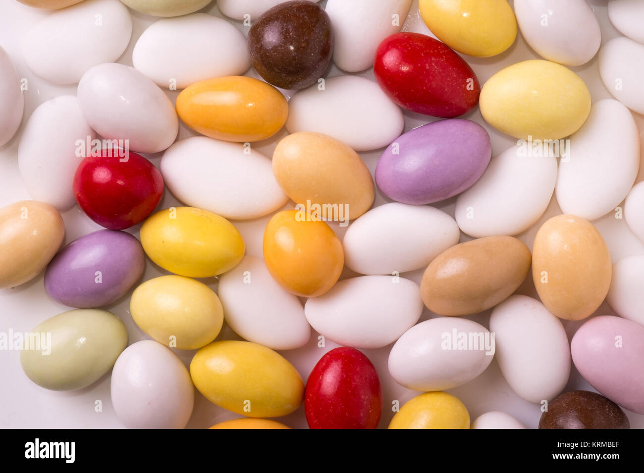 Colored sugared almonds arranged on a white background Stock Photo - Alamy