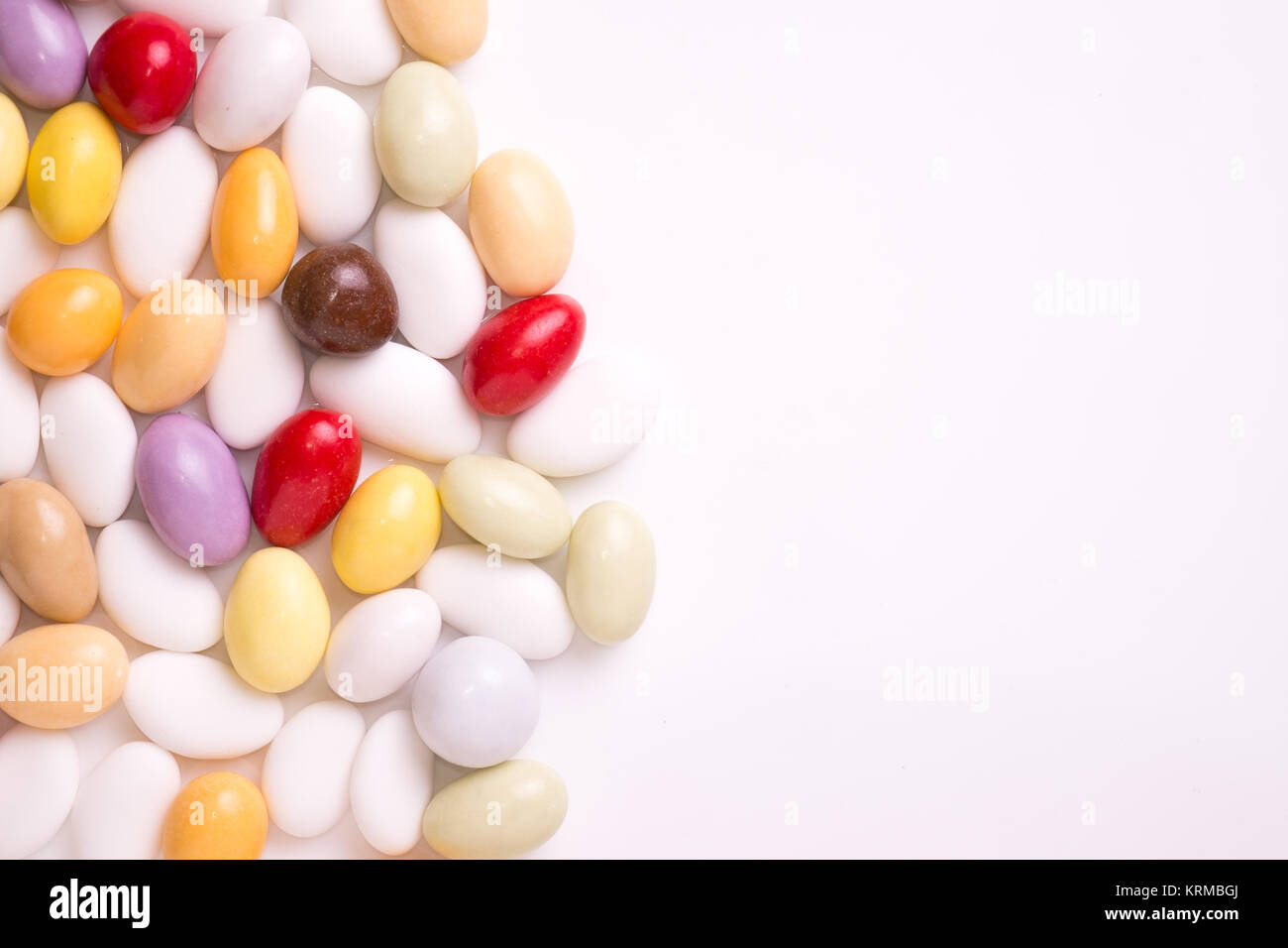 Colored sugared almonds arranged on a white background Stock Photo - Alamy