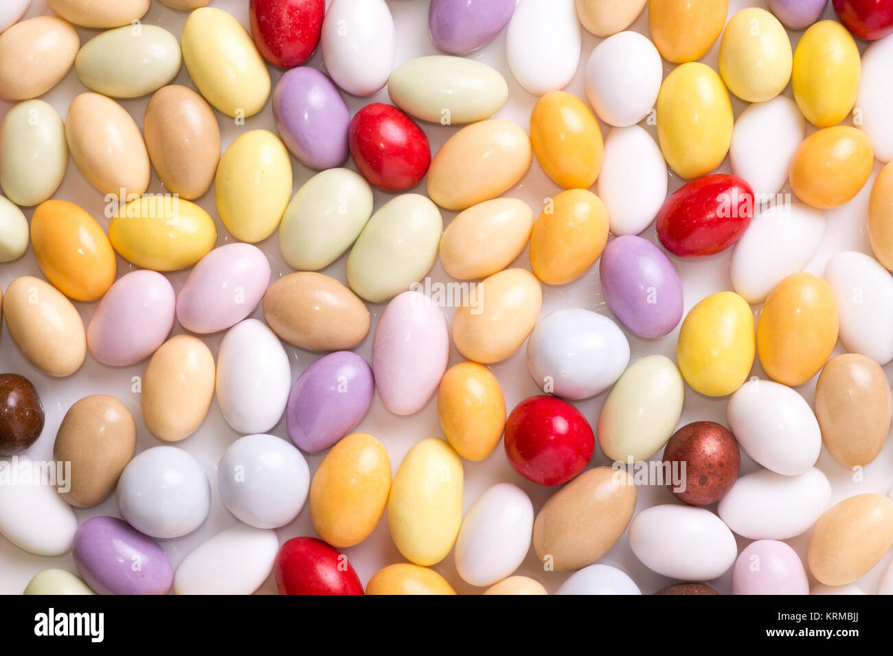 Colored sugared almonds arranged on a white background Stock Photo - Alamy