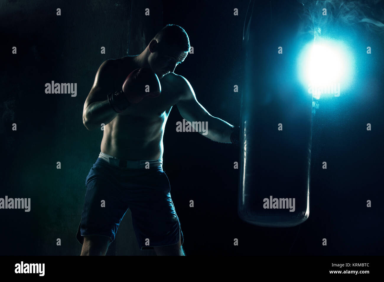 Male boxer boxing in punching bag Stock Photo - Alamy