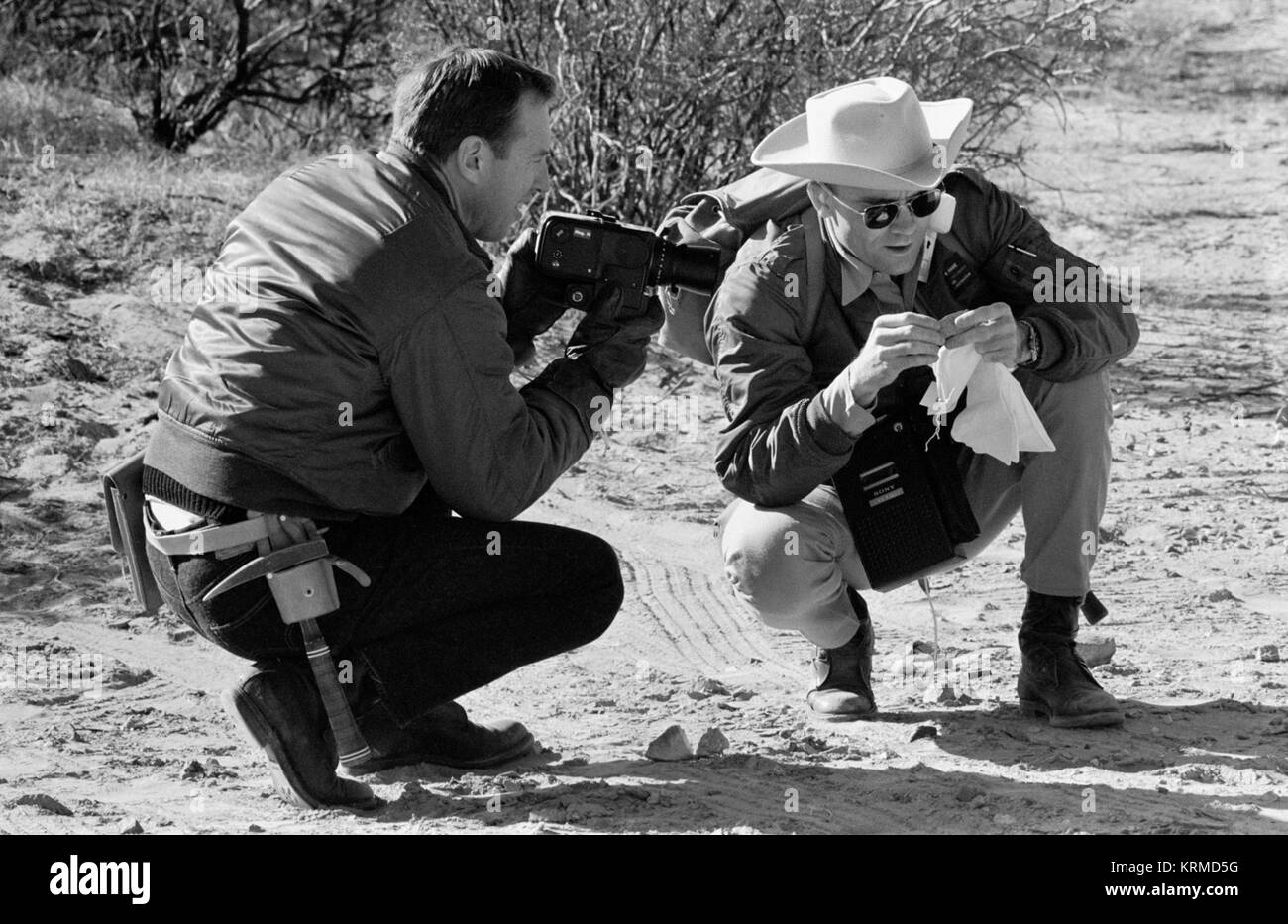 Back-up Commander Jim Lovell (left) looking on and holding a Hasselblad ...