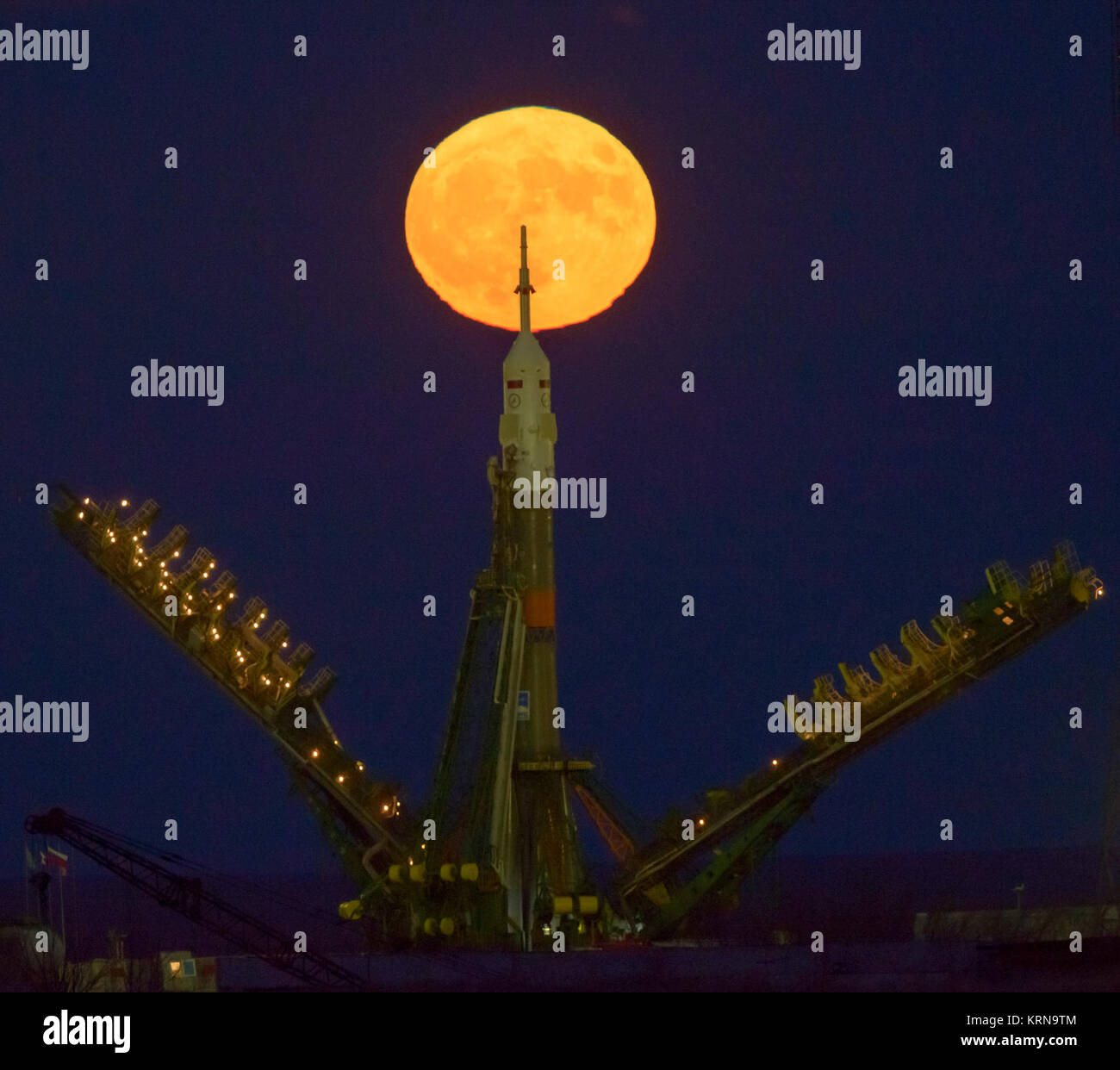 The moon, or supermoon, is seen rising behind the Soyuz rocket at the ...