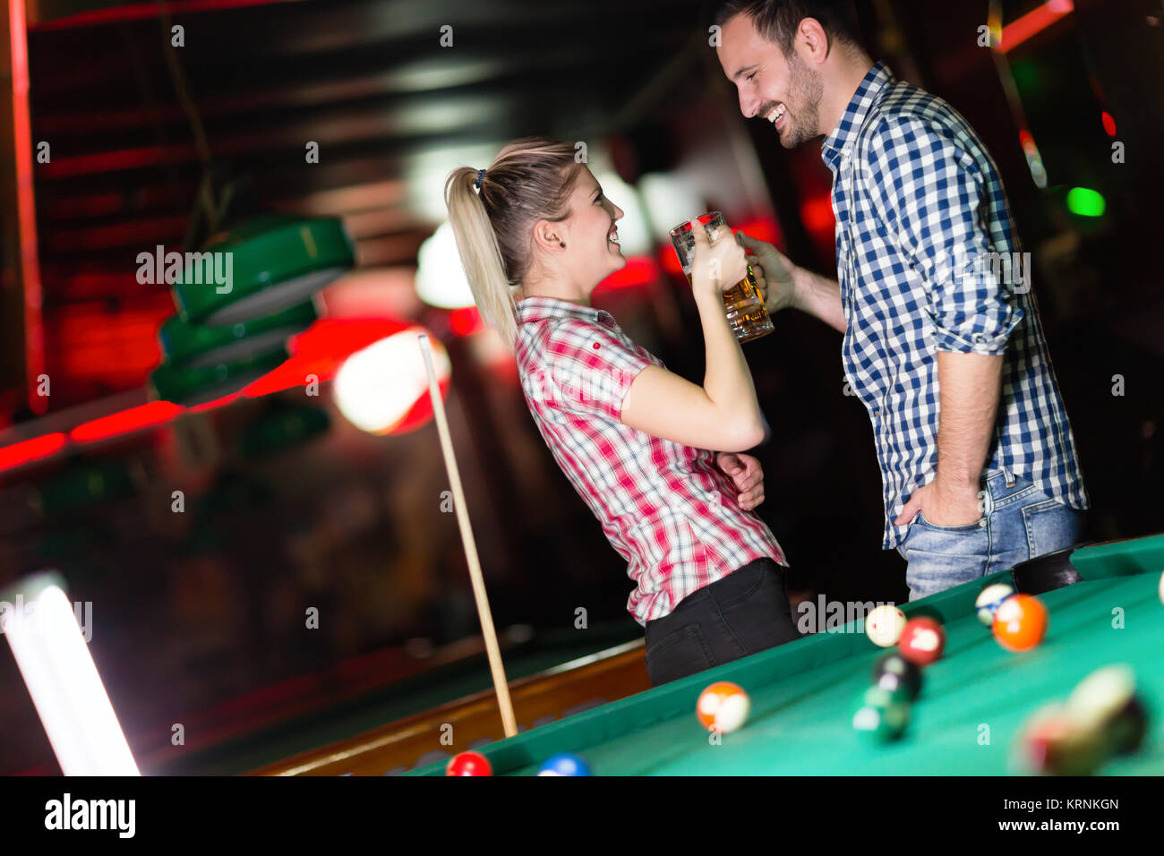 Happy couple drinking beer and playing snooker Stock Photo - Alamy