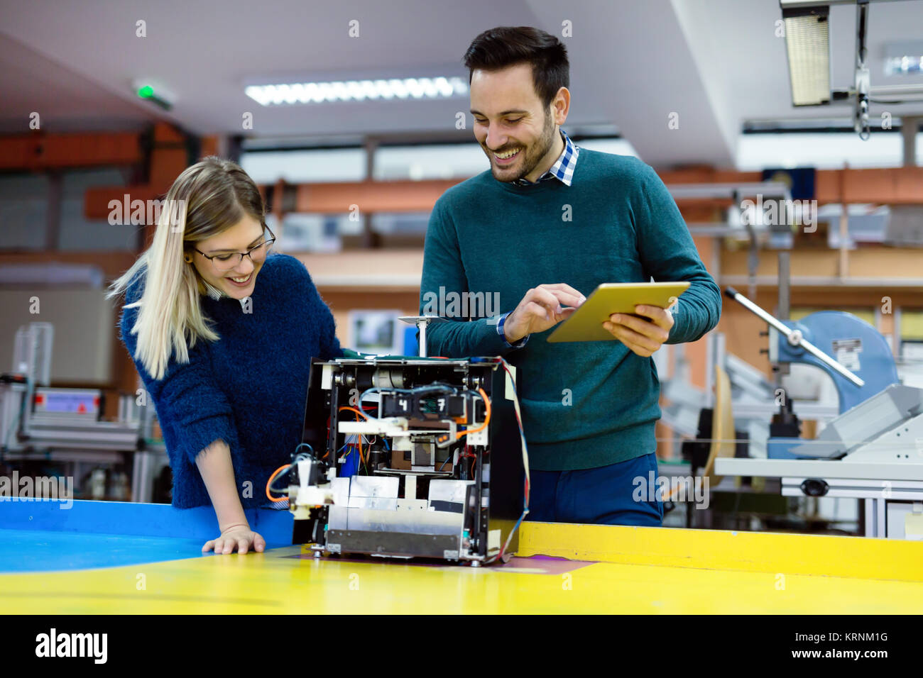 Young students of robotics preparing robot for testing Stock Photo - Alamy