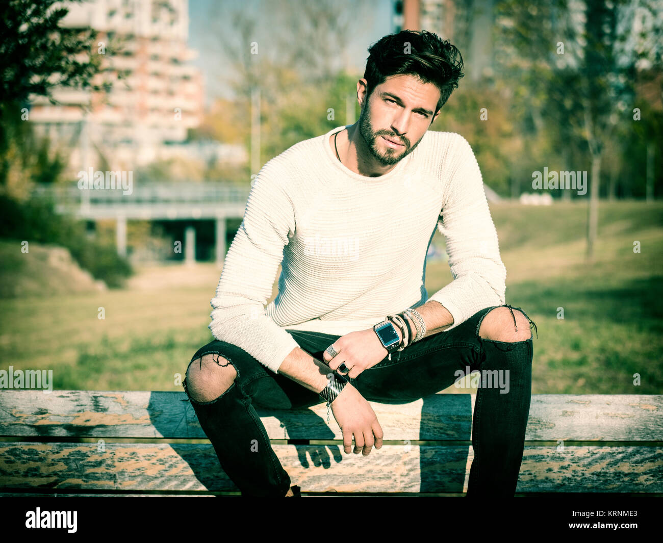 One handsome man in urban setting in European city, sitting Stock Photo ...