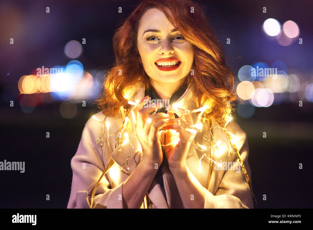 Cheerful woman with light bulb Stock Photo - Alamy