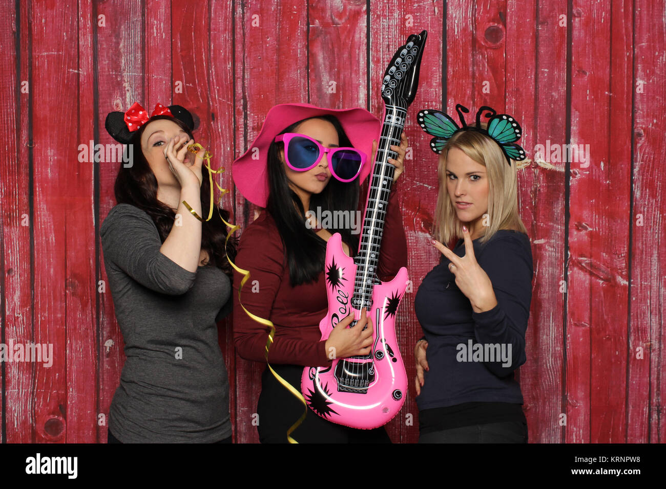 3 girls are having fun with a photo box Stock Photo - Alamy