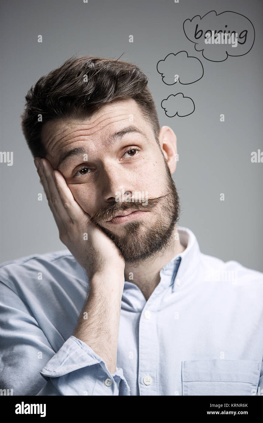 Man is looking bored. Over gray background Stock Photo - Alamy