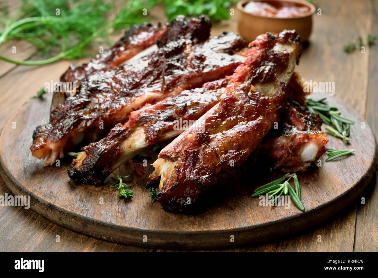 Grilled sliced barbecue pork ribs on wooden board, shallow depth of ...