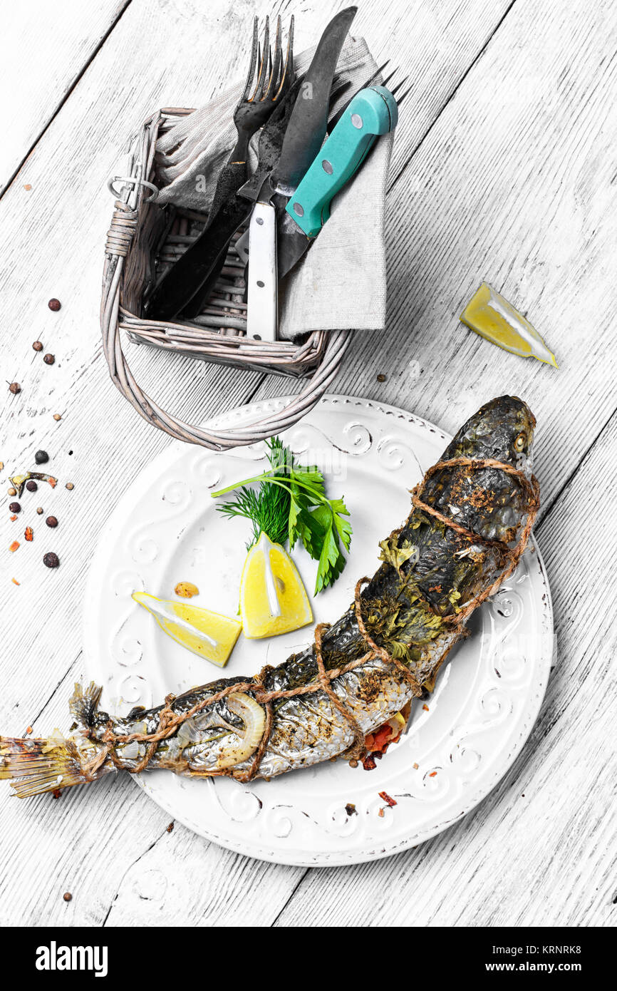 whole carcass of fish grilled on light plate on light background Stock ...