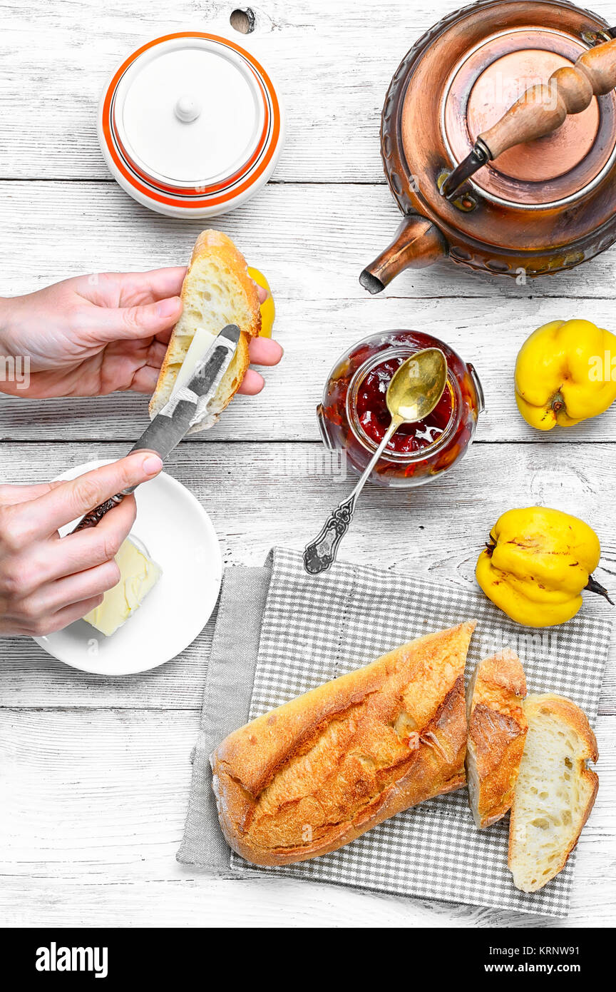 Hands preparing for morning breakfast with bread butter and jam for tea ...