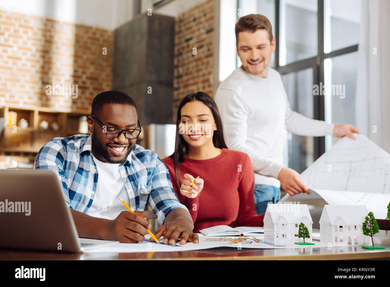 Three positive colleagues preparing blueprint Stock Photo - Alamy