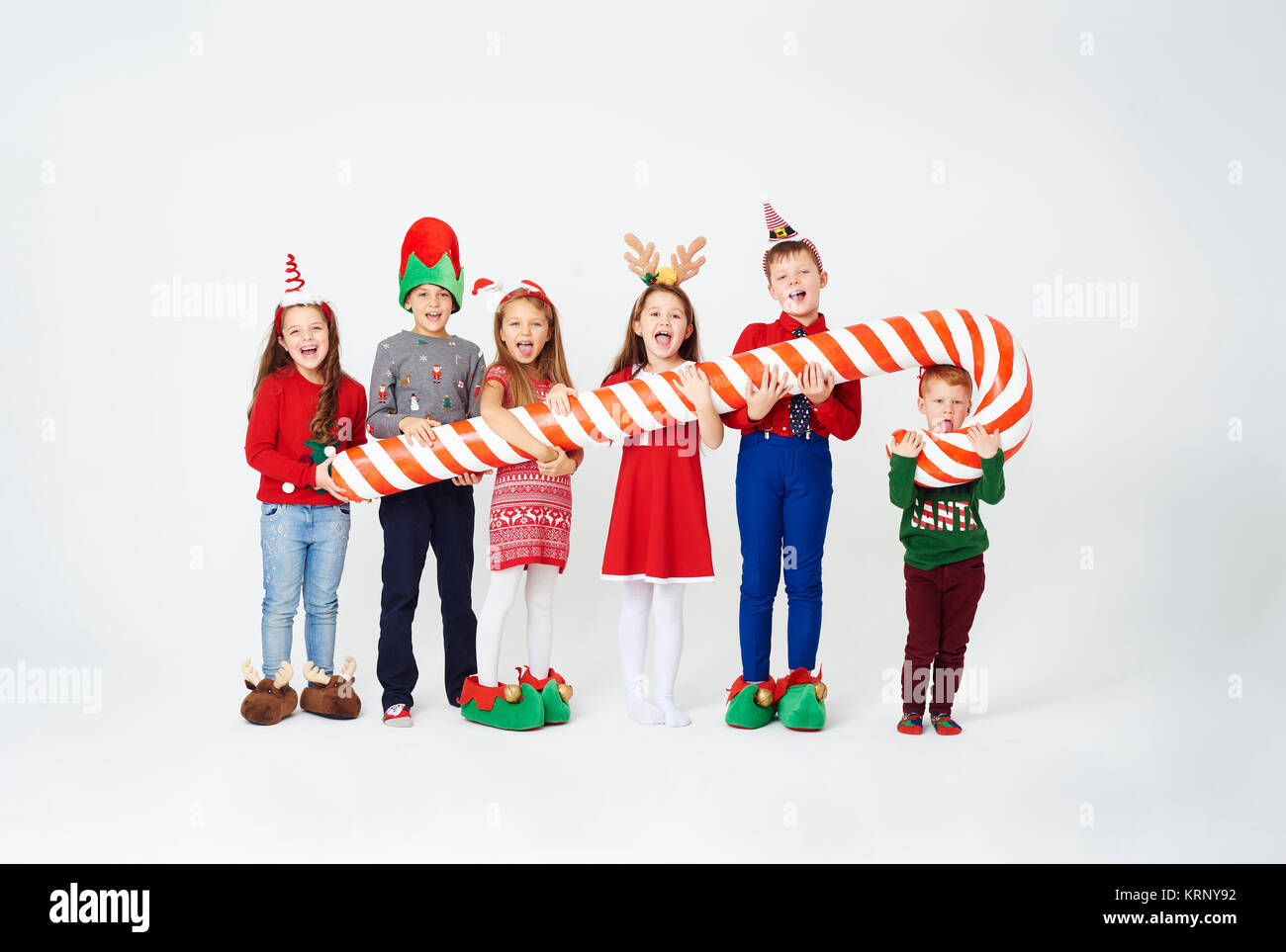 Happy children holding huge candy cane Stock Photo - Alamy