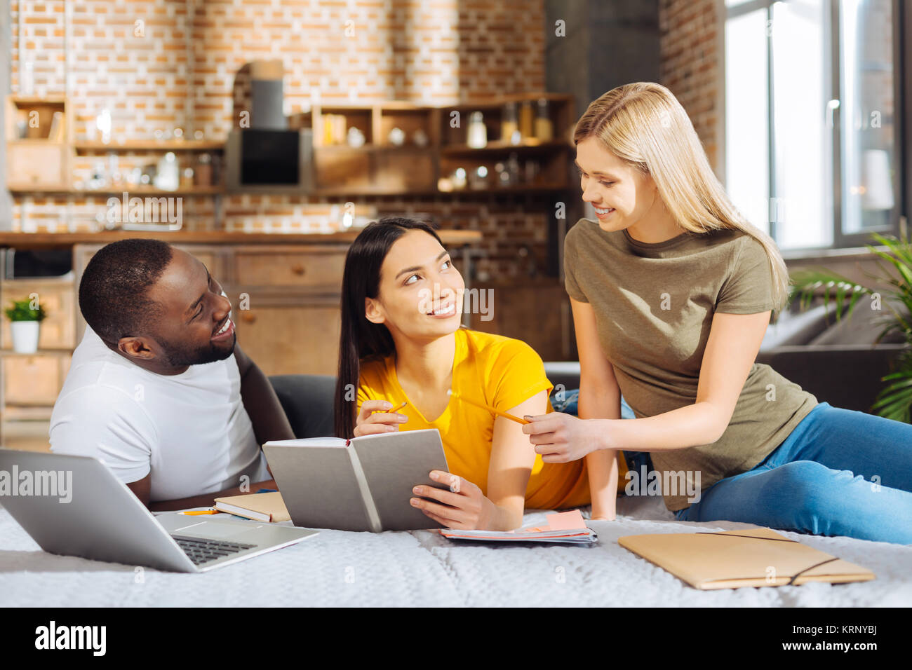 Three musing merry friends preparing project Stock Photo - Alamy