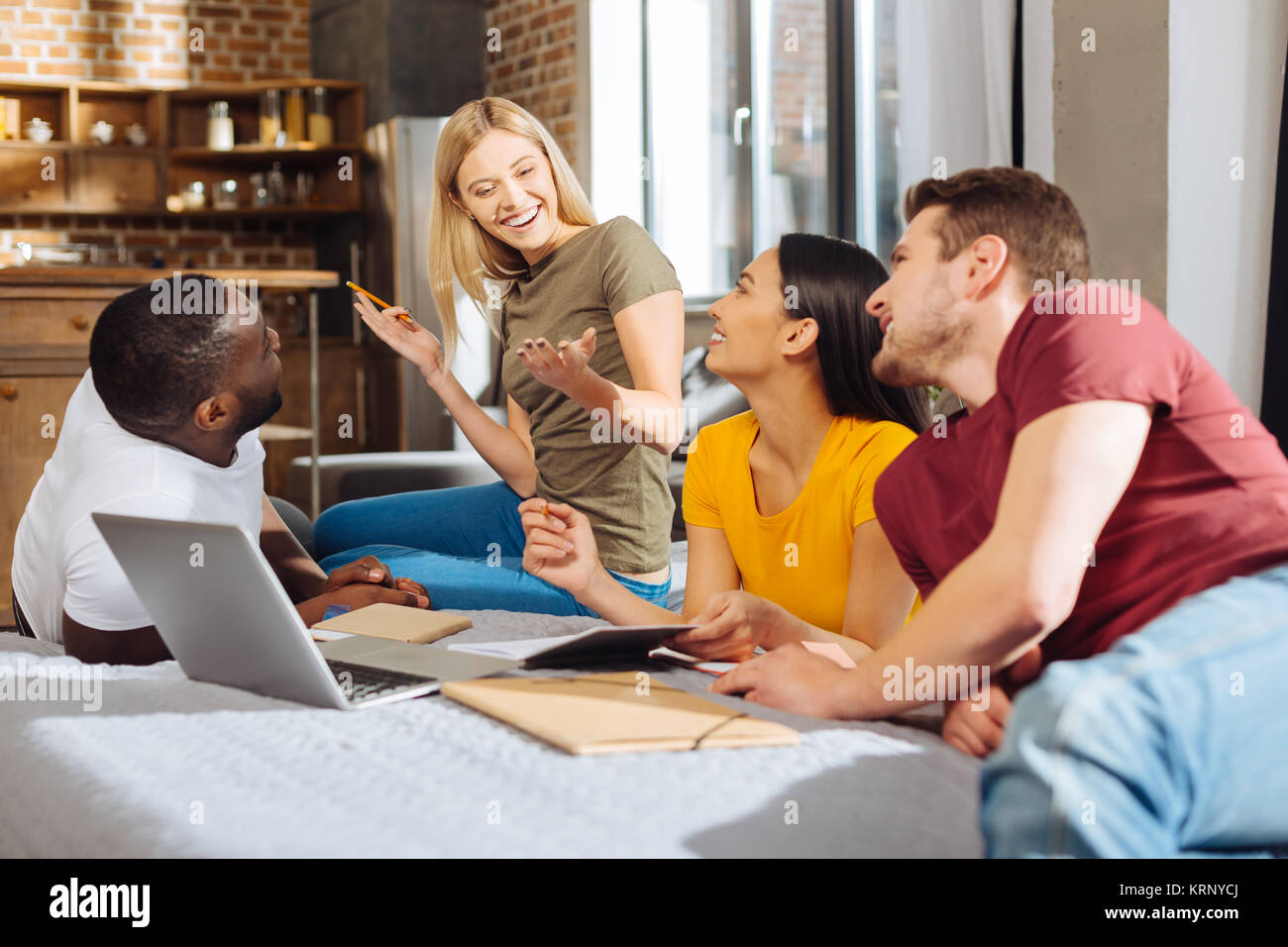 Four vigorous young students inviting device Stock Photo - Alamy