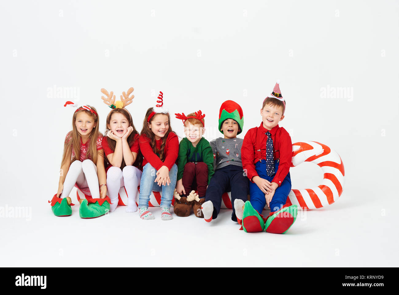 Shot of children sitting on big candy cane Stock Photo - Alamy