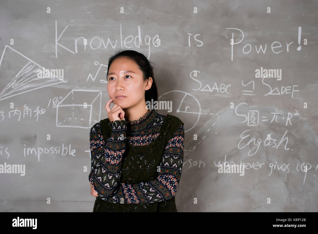 Reflective young woman trying to solve an equation Stock Photo - Alamy