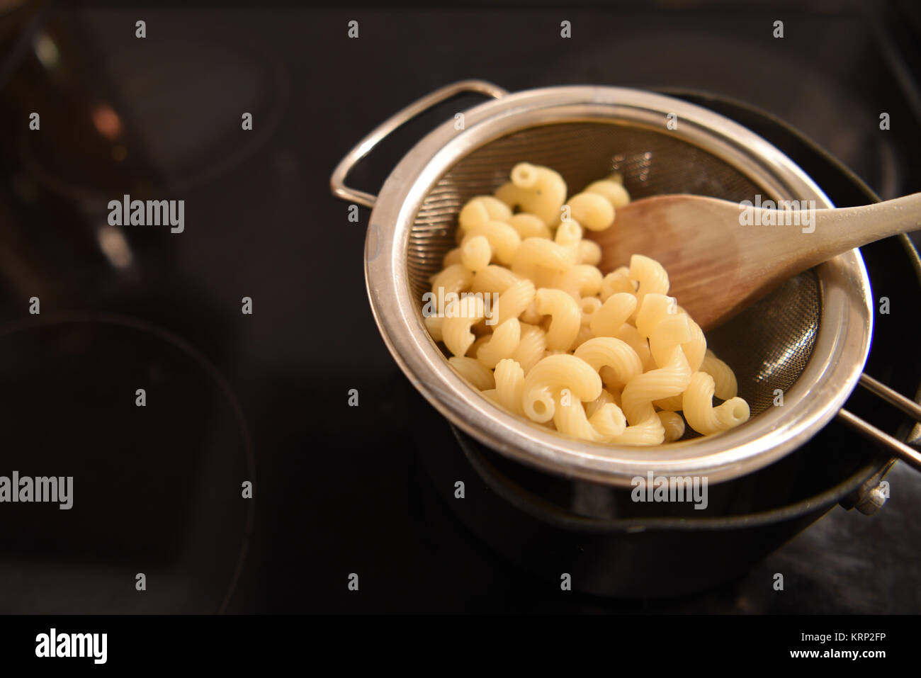food photography image of cooked pasta spiral shapes in a sieve with ...
