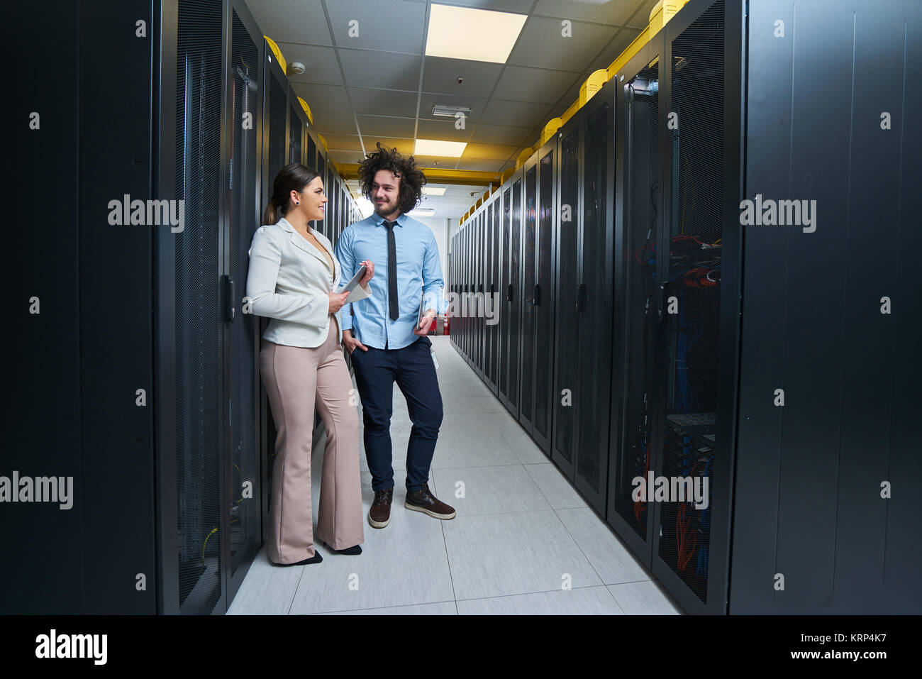 Young couple working at a data center. Black server room Stock Photo ...