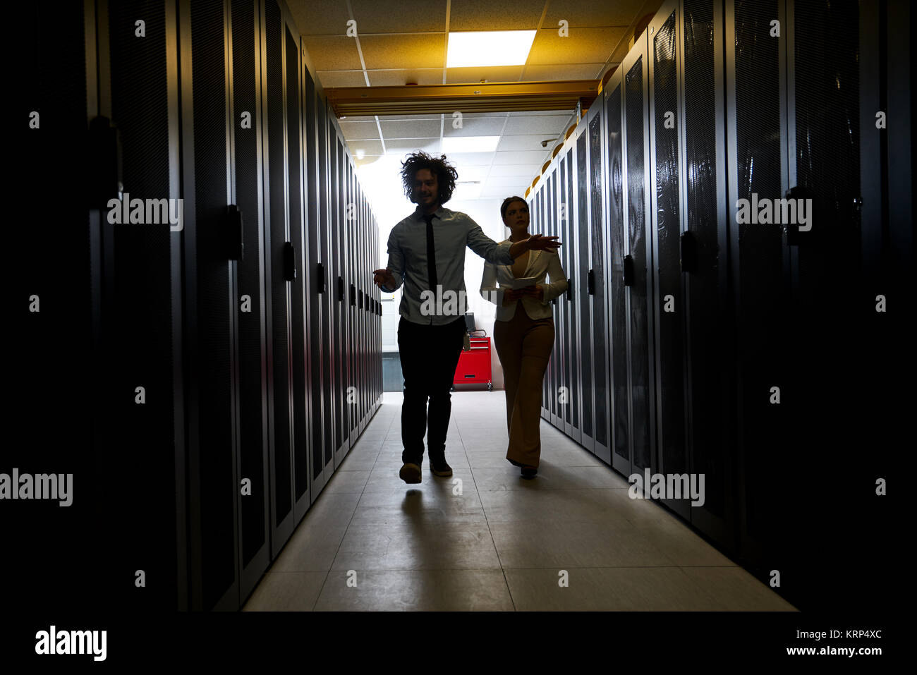 Young couple working at a data center. Black server room Stock Photo ...