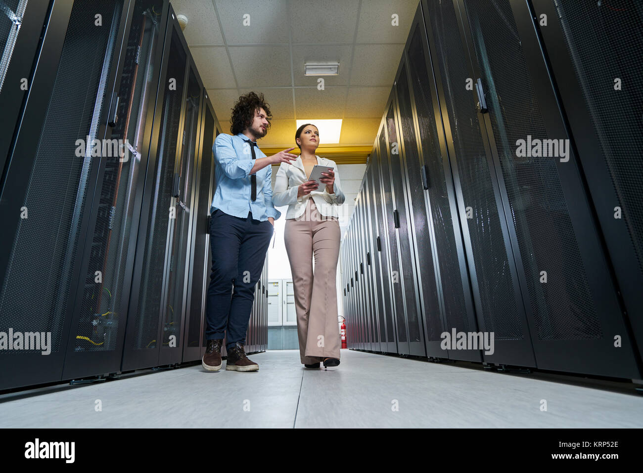 Young couple working at a data center. Black server room Stock Photo ...