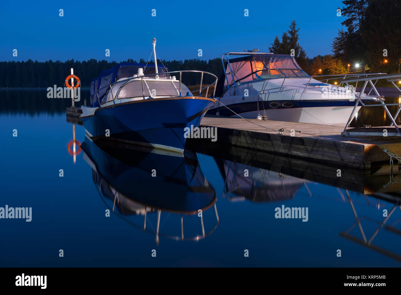 Motor boats rest at night tied to the pier Stock Photo - Alamy