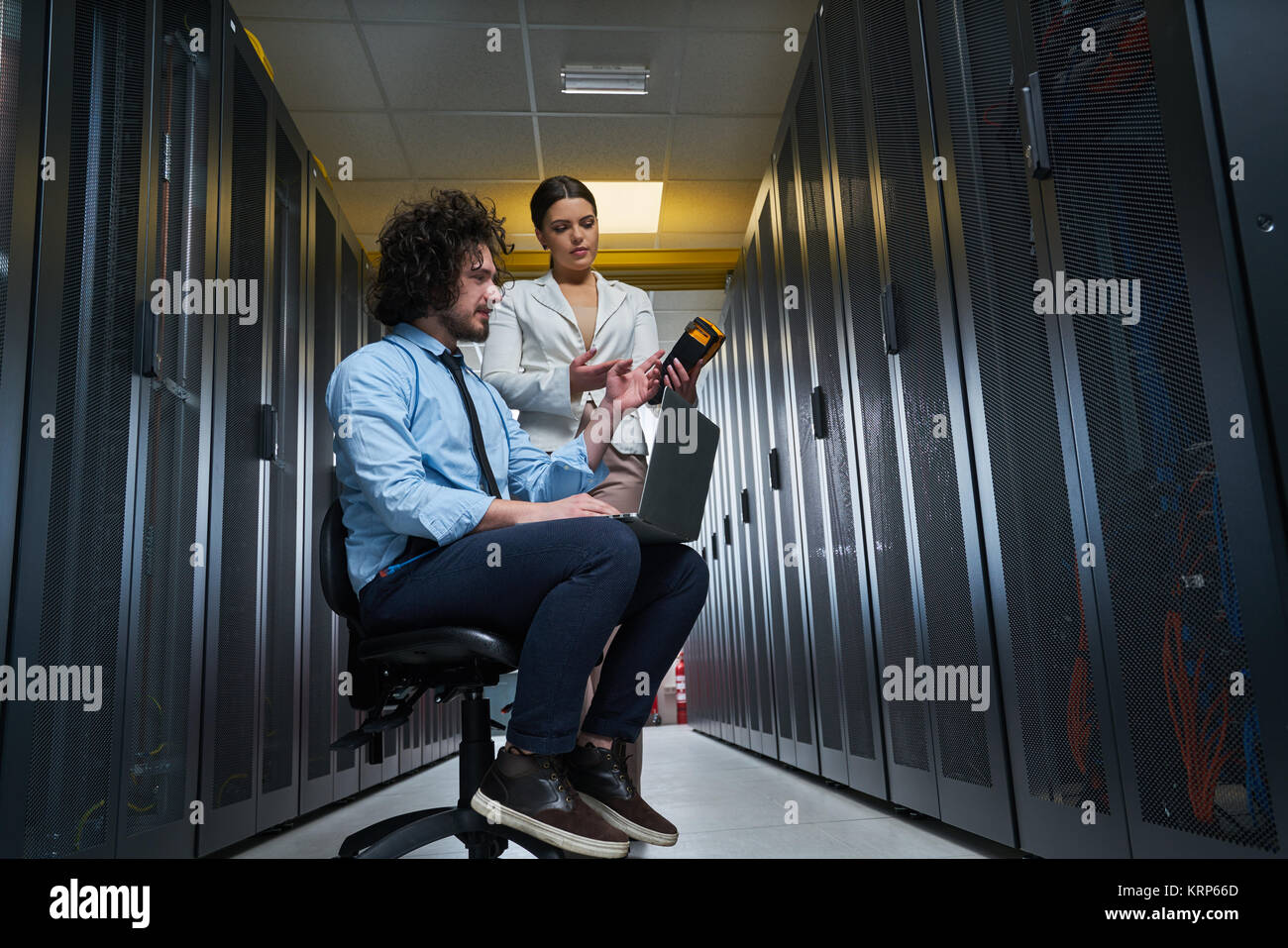 two young technicians working at a data center on server maintenance ...