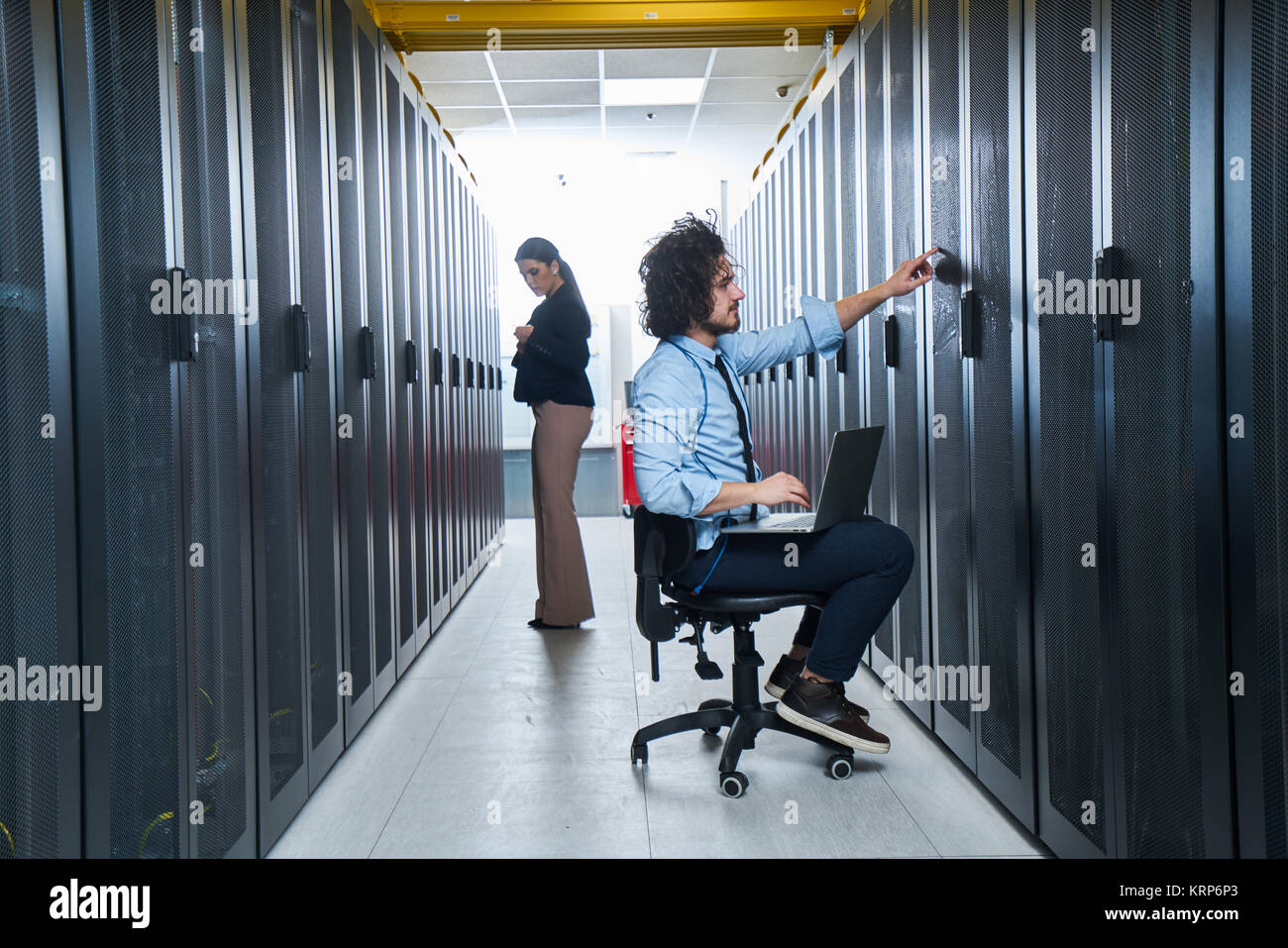 two young technicians working at a data center on server maintenance ...