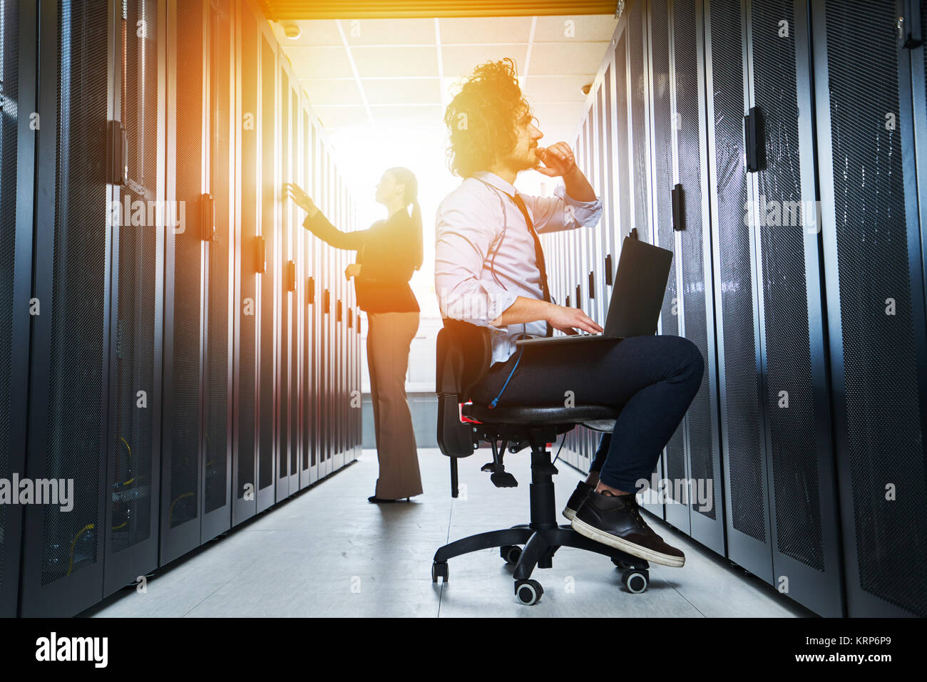 two young technicians working at a data center on server maintenance ...