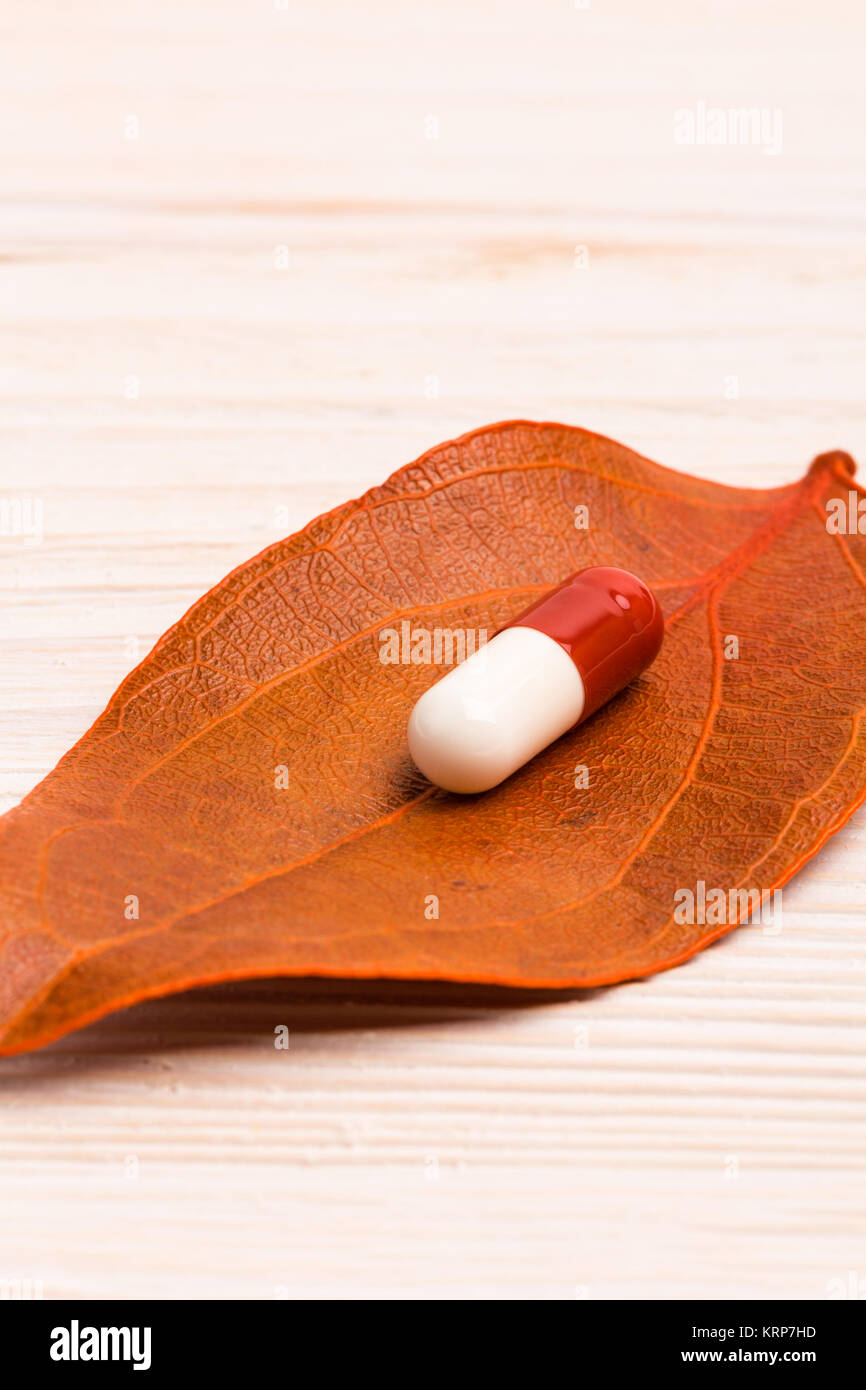 Medical pill on single orange leaf Stock Photo - Alamy