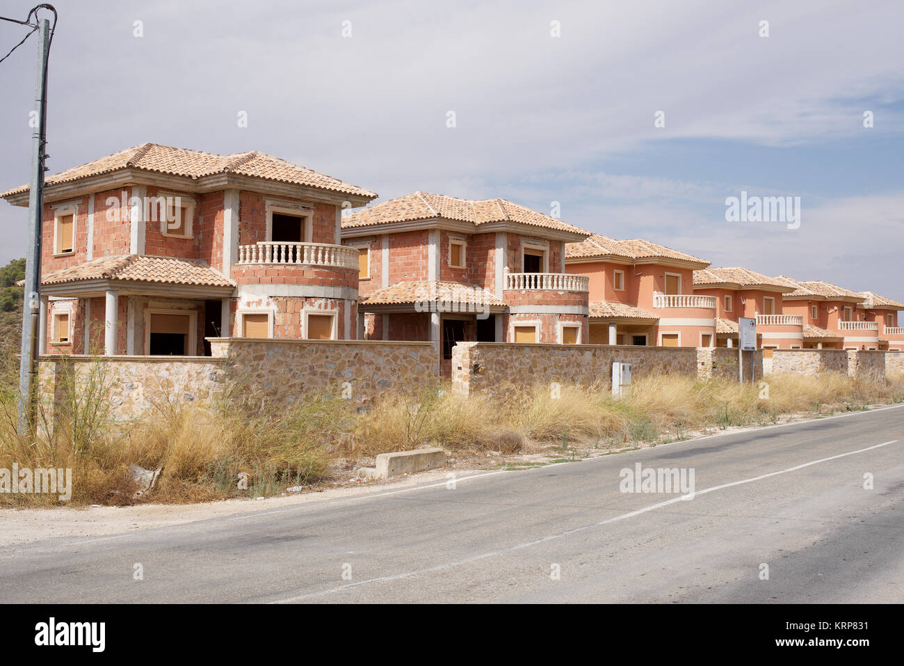 Incomplete empty villas by the roadside Stock Photo - Alamy
