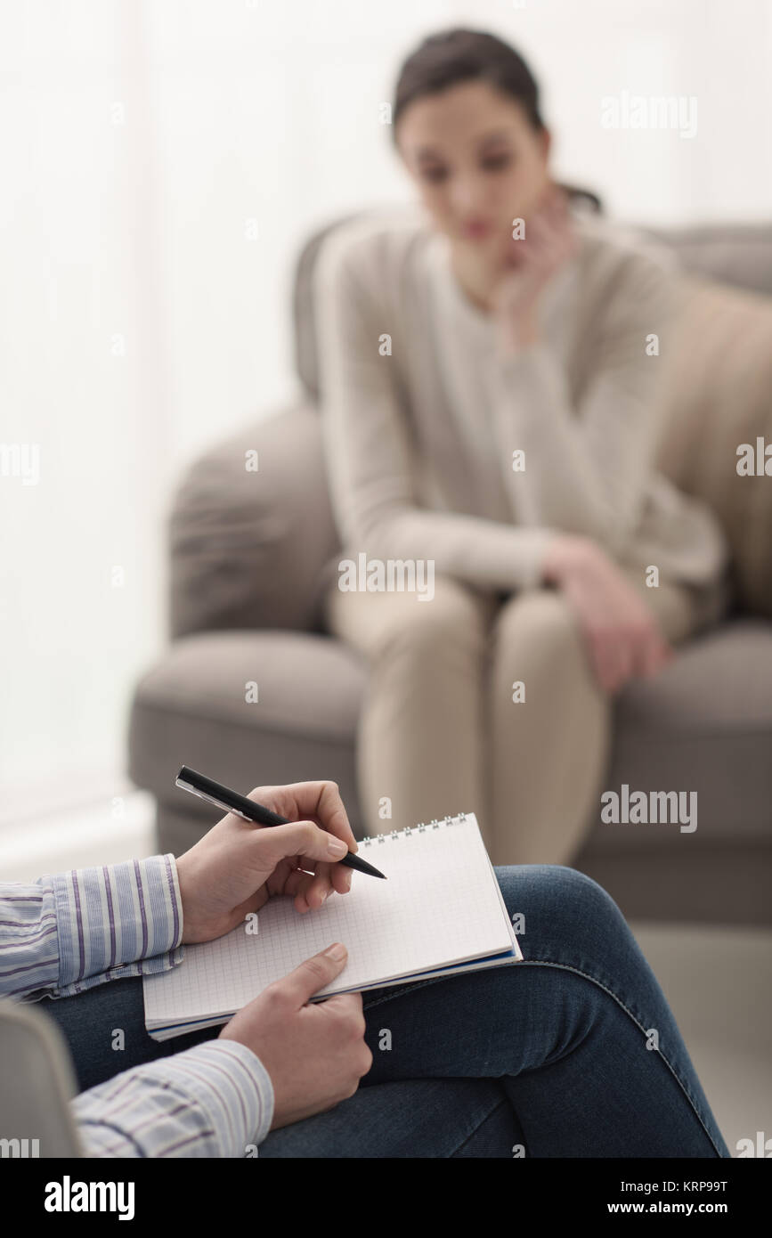Psychologist listening to her patient and writing down notes, mental ...