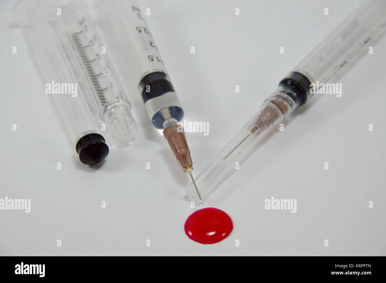 hypodermic syringe and red drop on white background Stock Photo - Alamy
