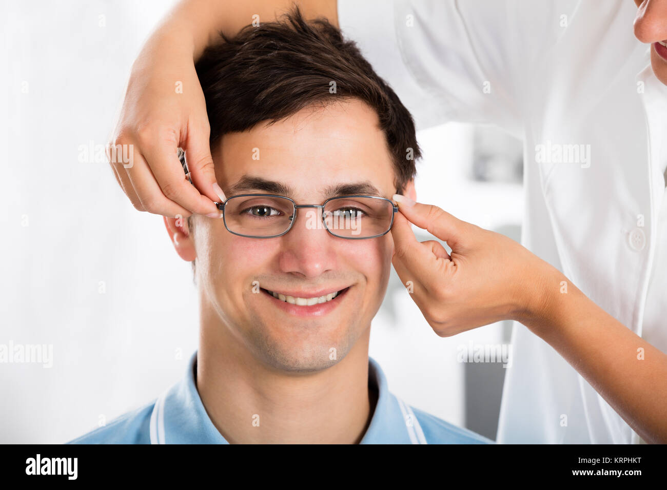 An Optician Helping Male Patient With New Eyeglasses Stock Photo - Alamy