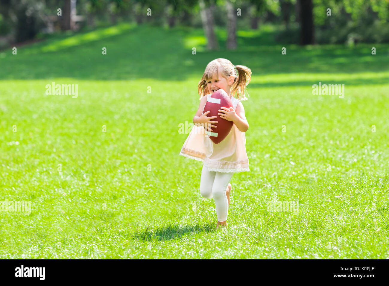 Little Girl Playing With Rugby Ball Stock Photo - Alamy