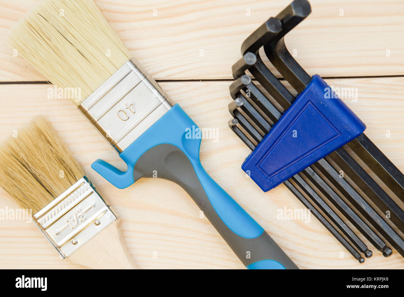 A set of repair tools- paint brushes and hex keys on a light uncolored ...