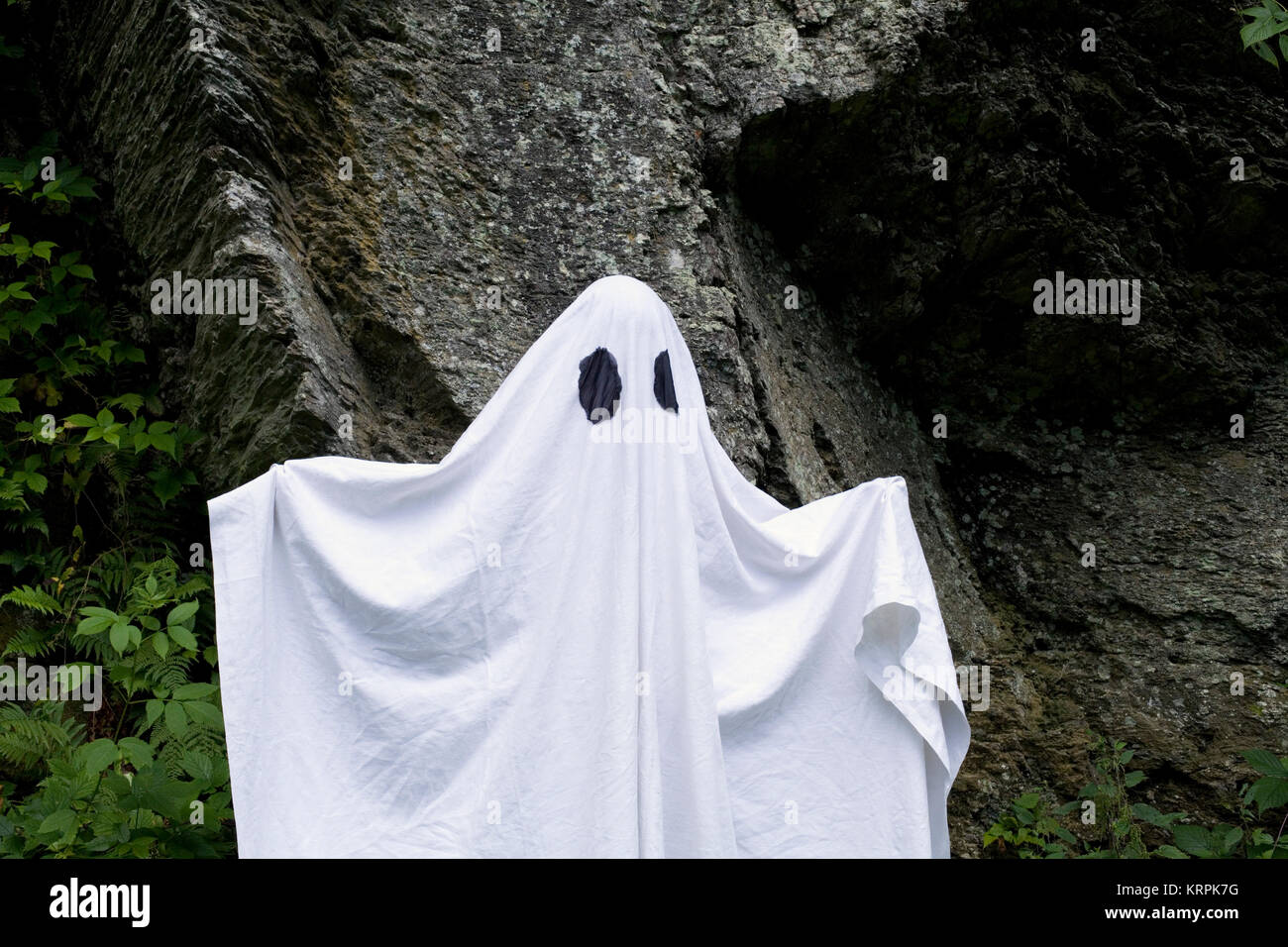 Ghost standing in front of a rock Stock Photo - Alamy