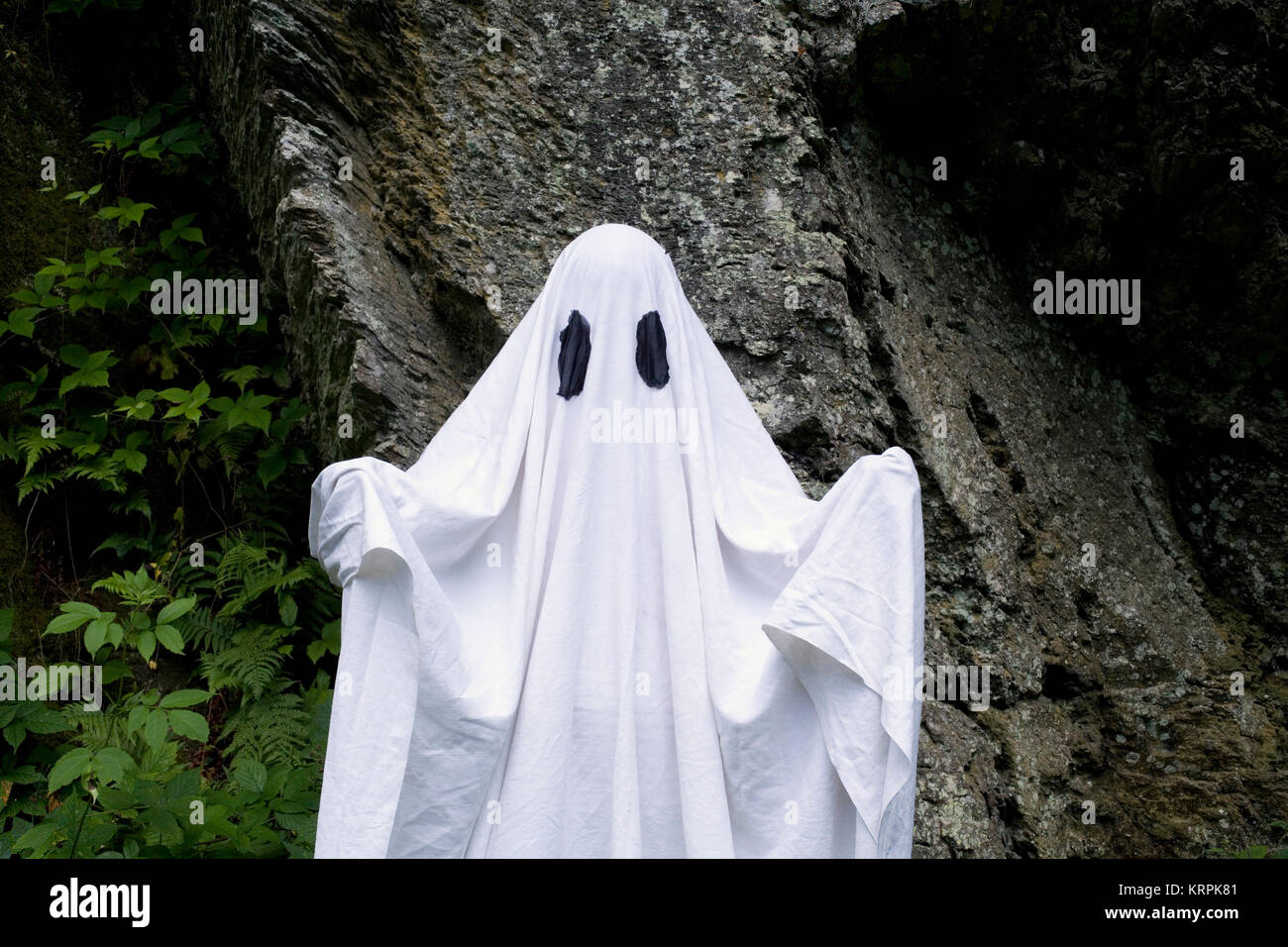 Ghost standing in front of a rock Stock Photo - Alamy