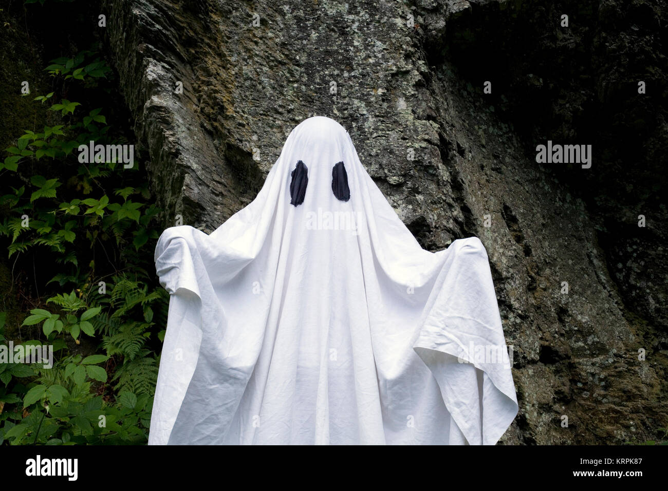 Ghost standing in front of a rock Stock Photo - Alamy
