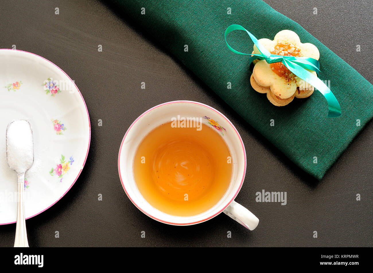 Tea time, top view of a tea cup with green napkin, biscuits, and saucer ...