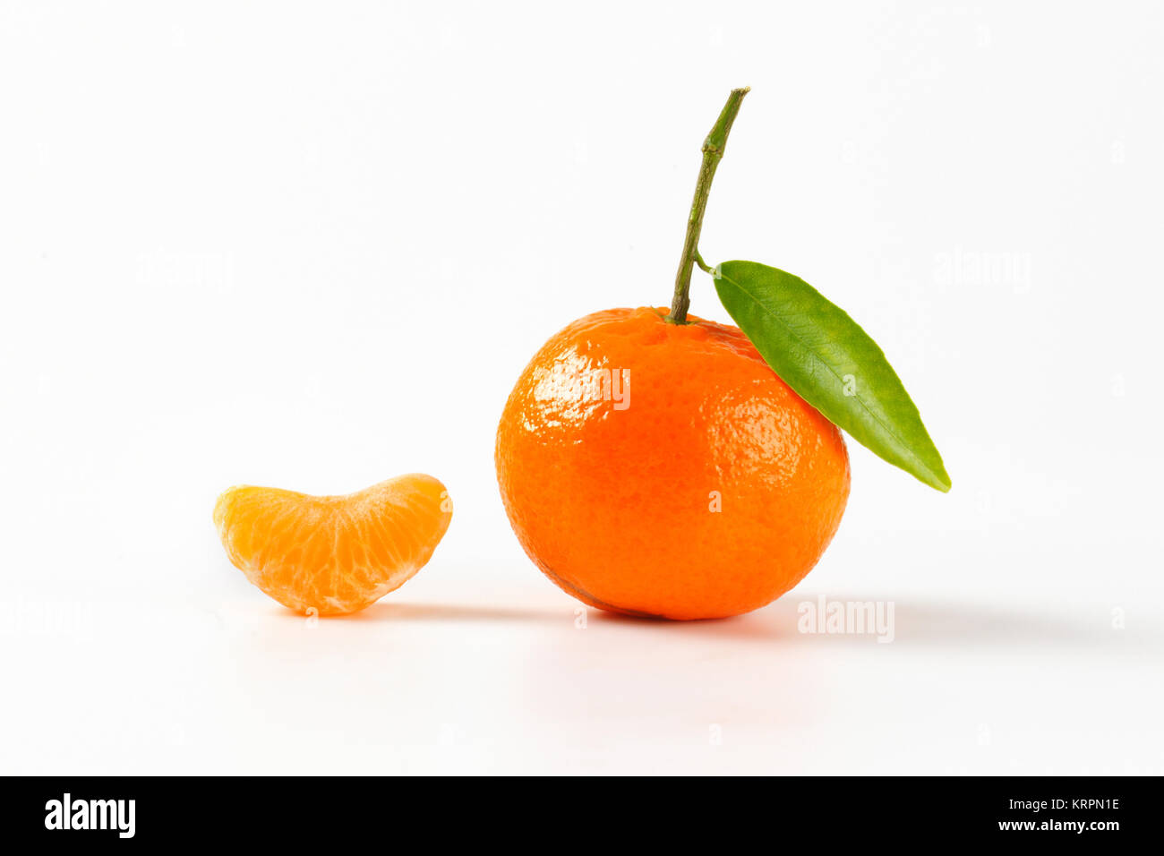 whole mandarin orange and one segment Stock Photo - Alamy