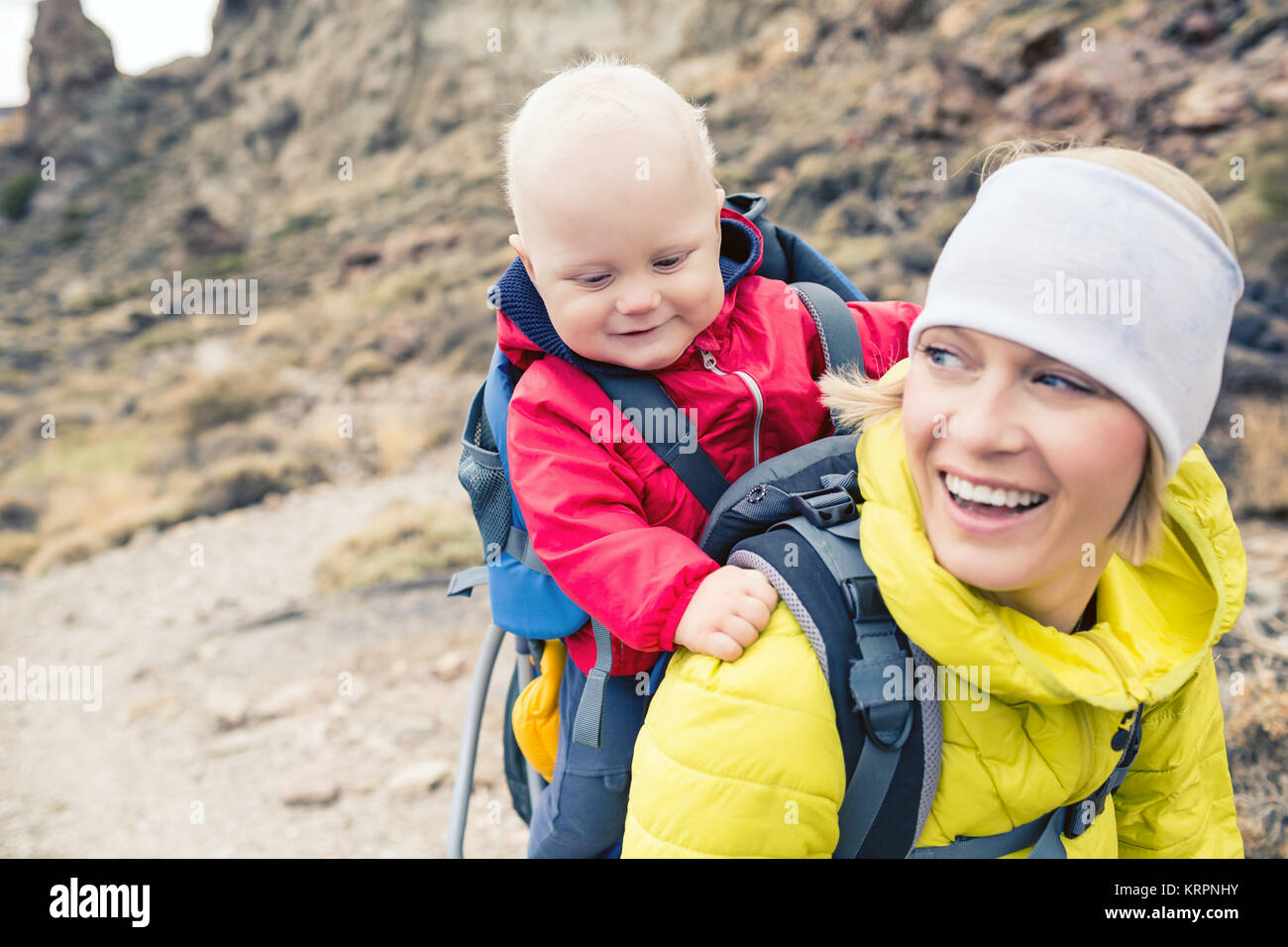 Happy mother with little boy travelling in backpack. Hiking adventure ...