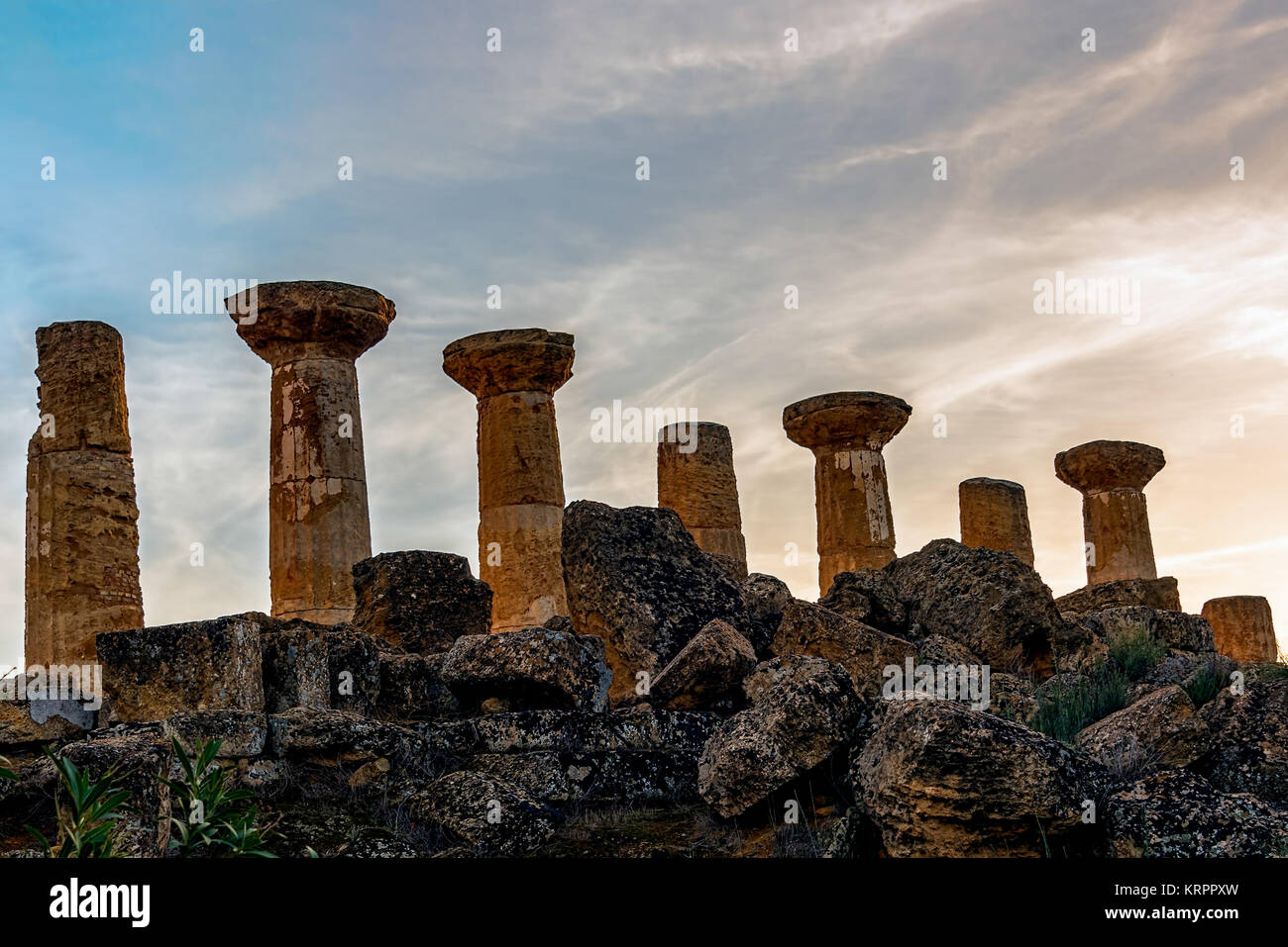 Antique city columns under sunset with scattered clouds Stock Photo - Alamy