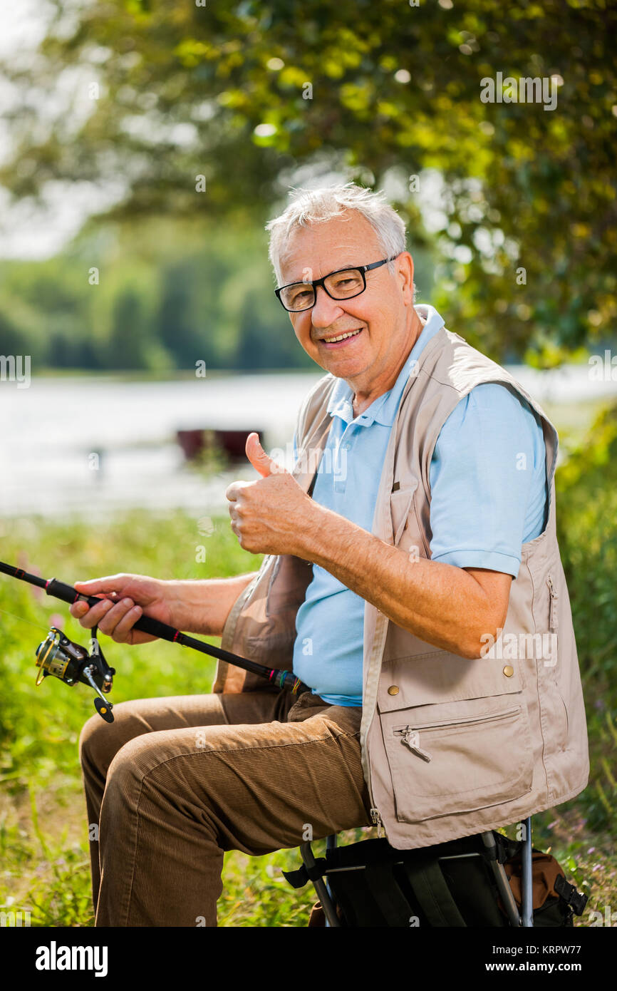 Happy senior man is fishing on sunny day Stock Photo - Alamy