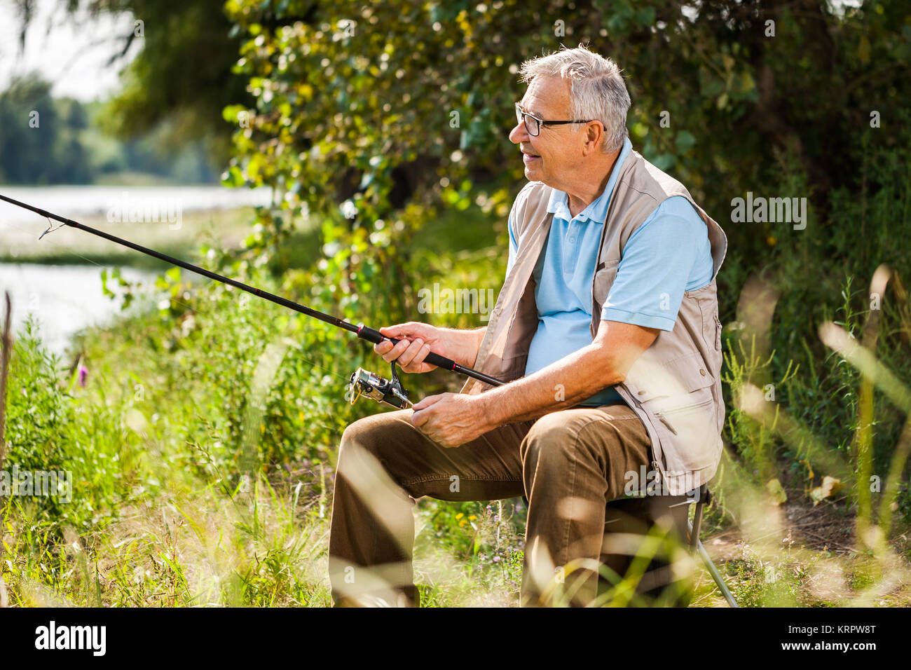 Happy senior man is fishing on sunny day Stock Photo - Alamy