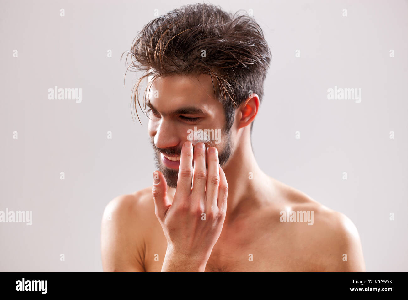 Young handsome man is applying skin cream to his face Stock Photo - Alamy
