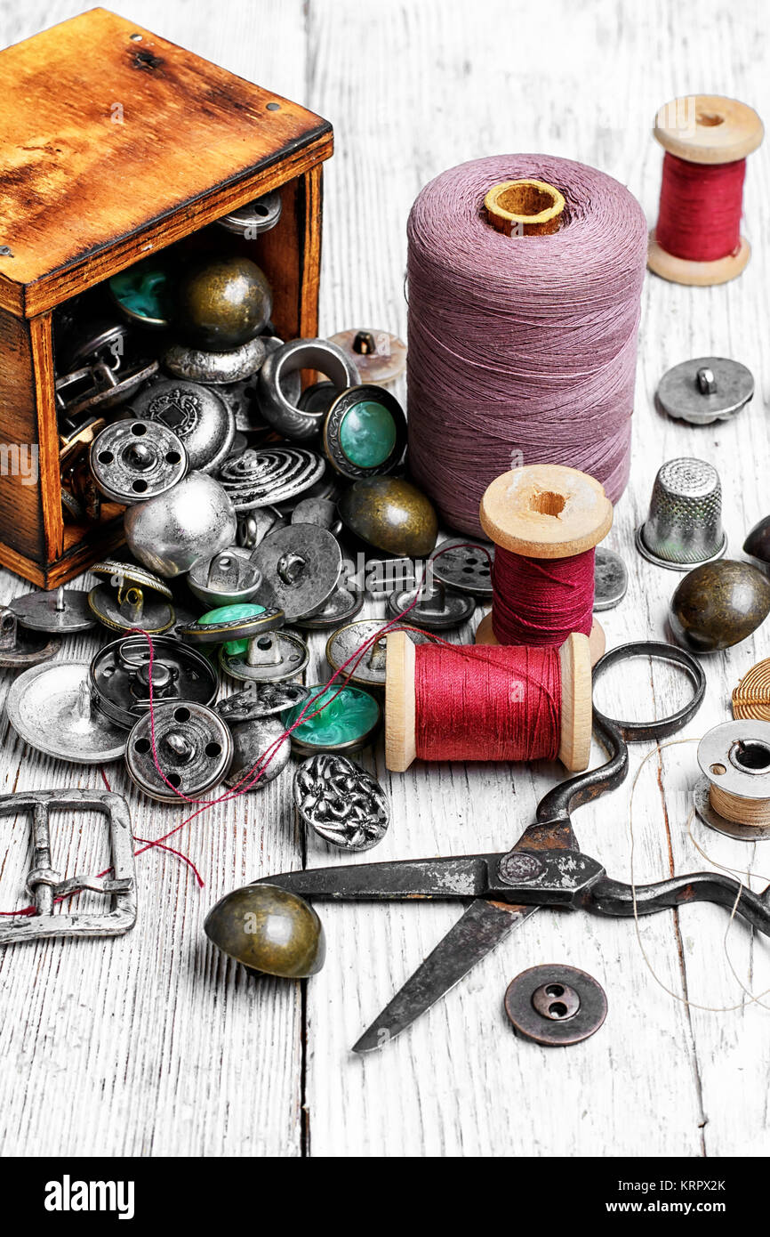 Scattered wooden boxes with iron buttons and sewing thread Stock Photo ...
