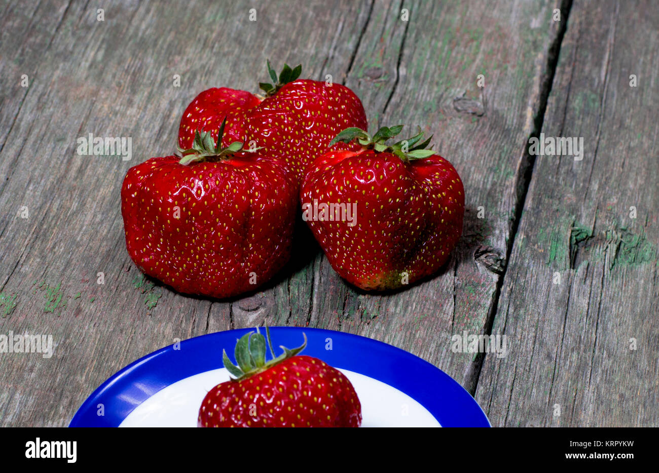 three beautiful big strawberries in group Stock Photo - Alamy